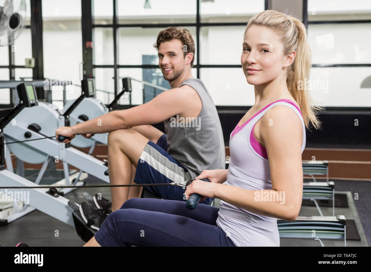 Portrait of a man and woman working out on rowing machine Stock Photo ...
