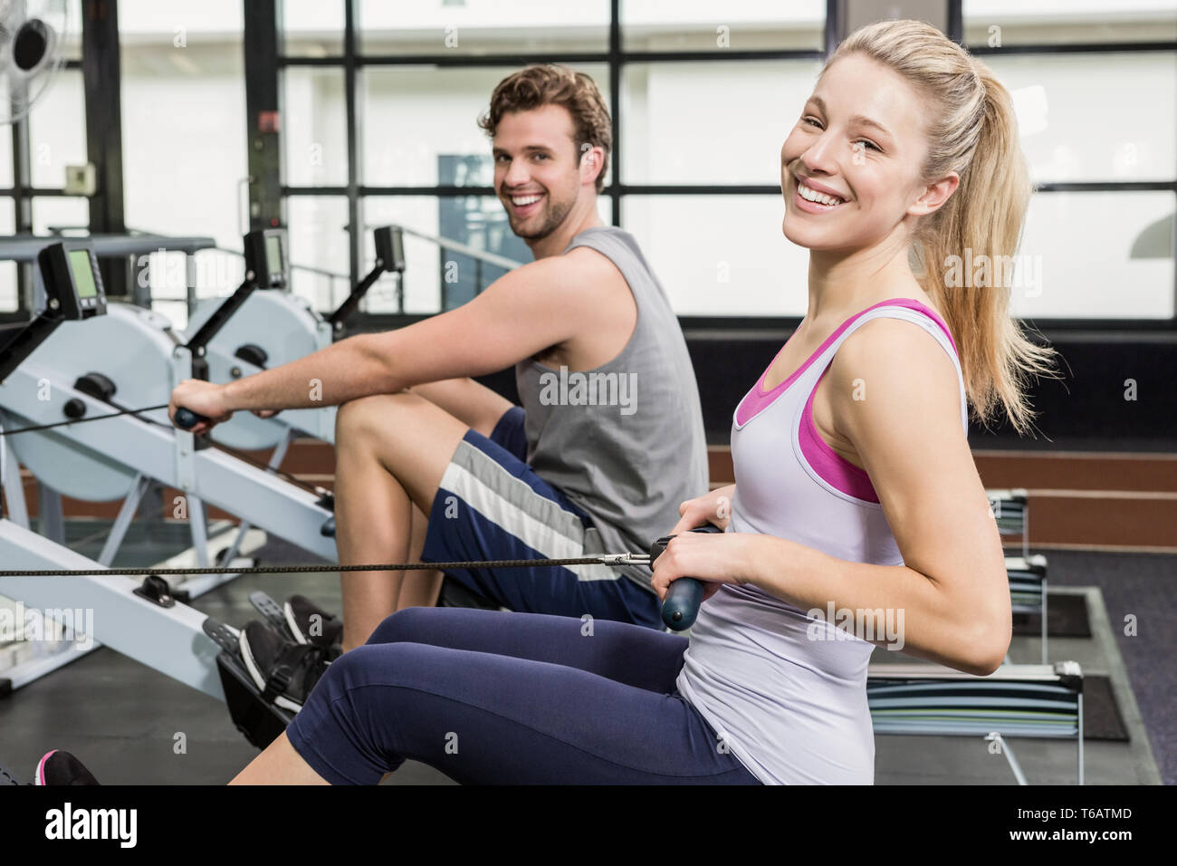 Young woman is exercising on a rowing machine hi-res stock photography ...