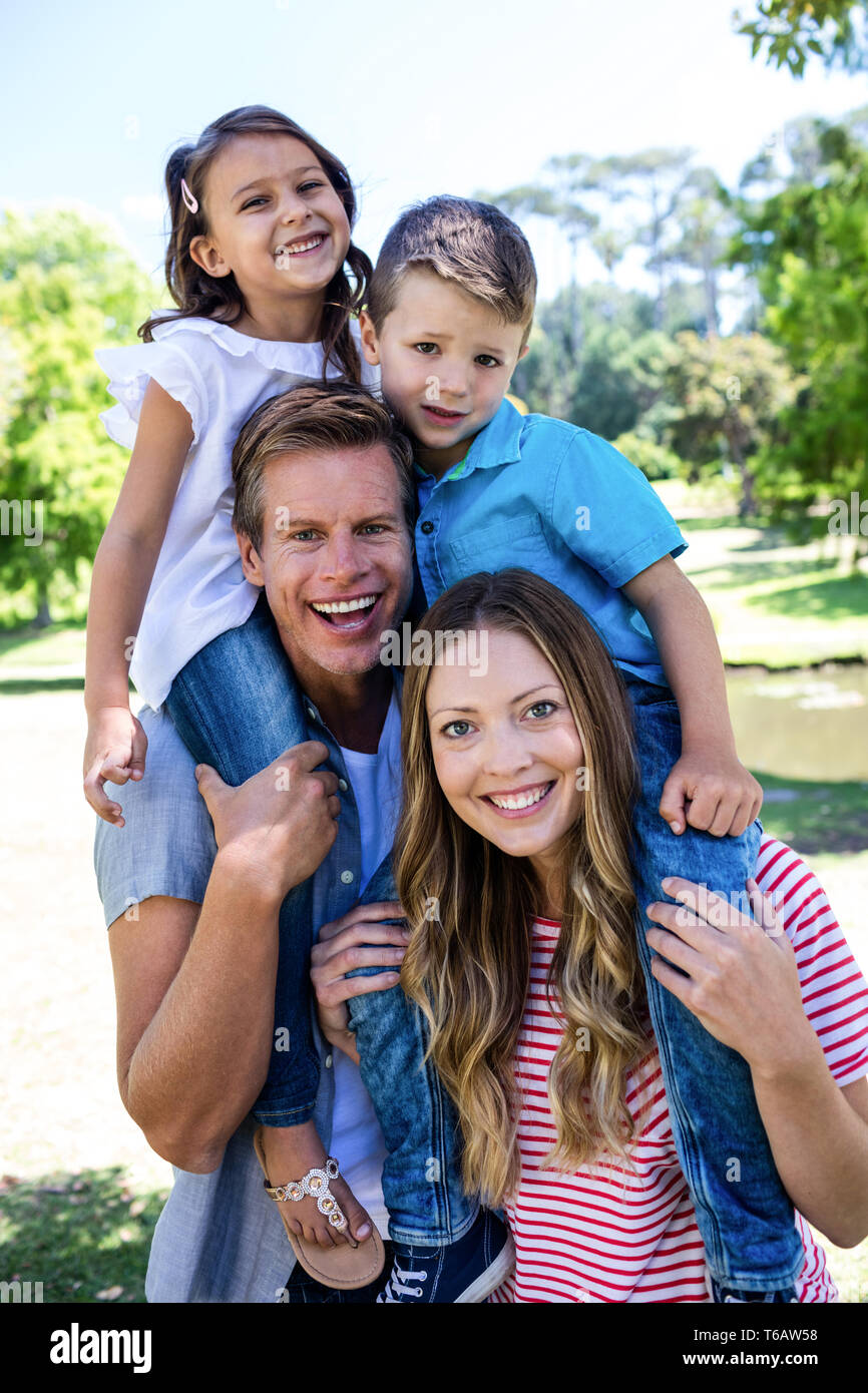 Happy parents carrying their kids on the shoulder in the park Stock ...
