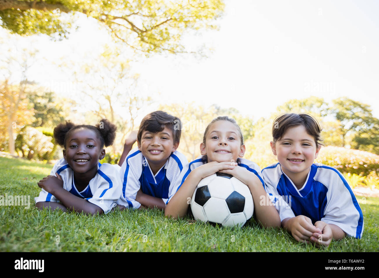 children soccer team smiling at camera while lying on the floor Stock ...