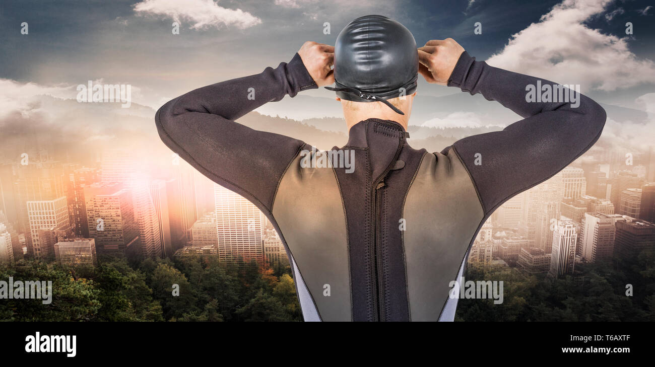 Composite image of rear view of swimmer in wetsuit wearing swimming ...