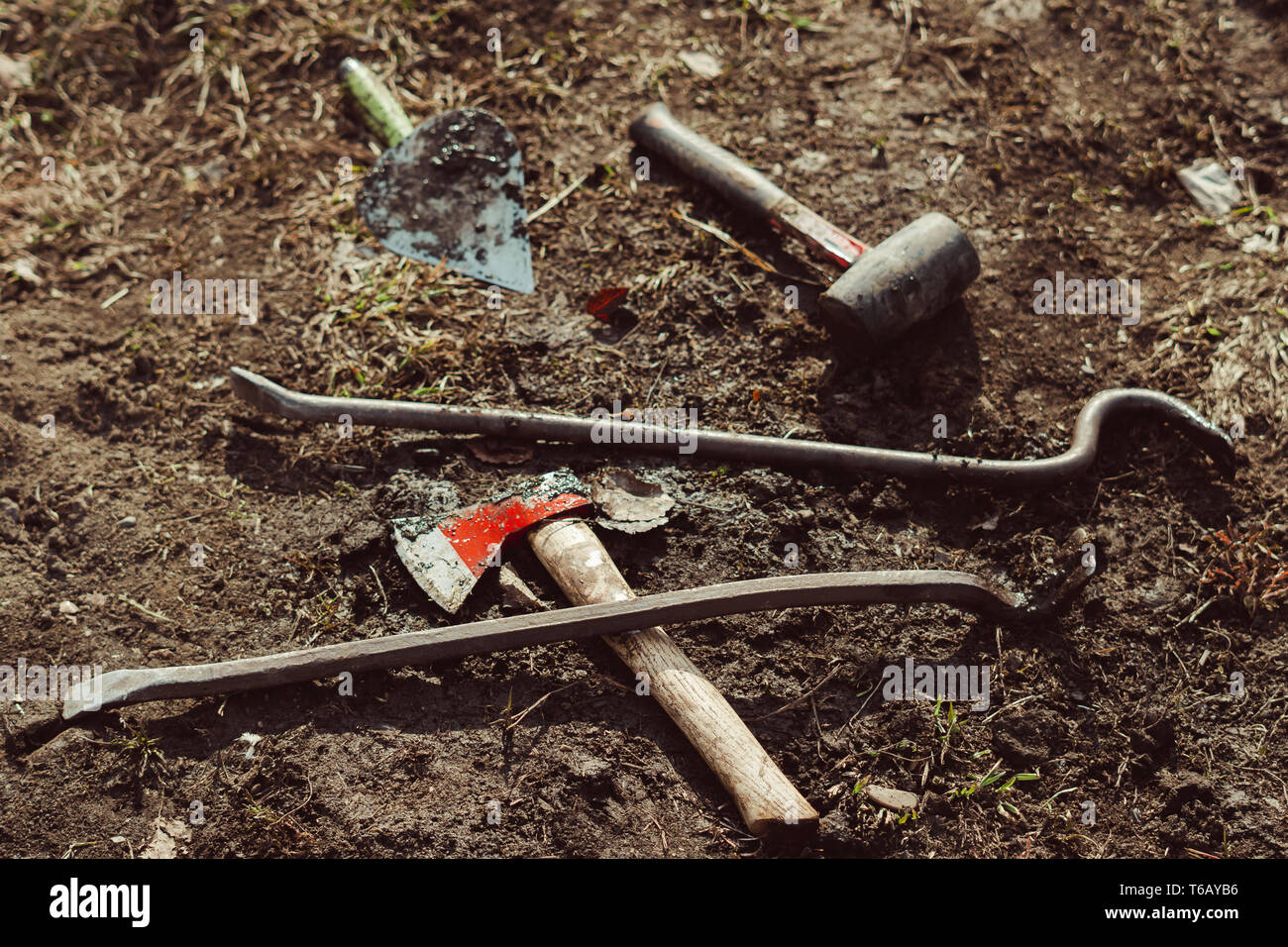 garden tools axe and crowbar lie on the ground Stock Photo - Alamy