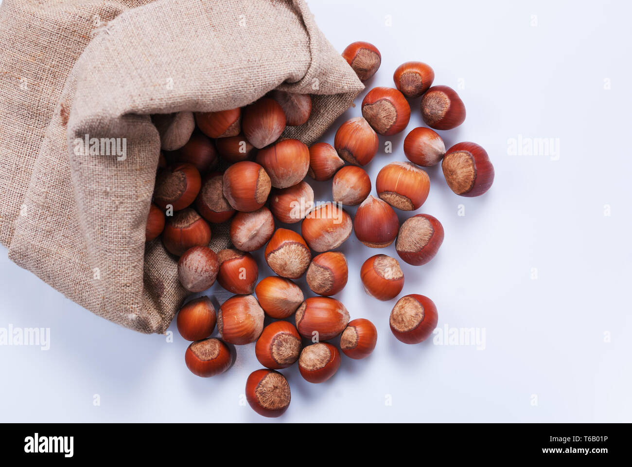 Unshelled hazelnuts in a bag on a white background Stock Photo - Alamy