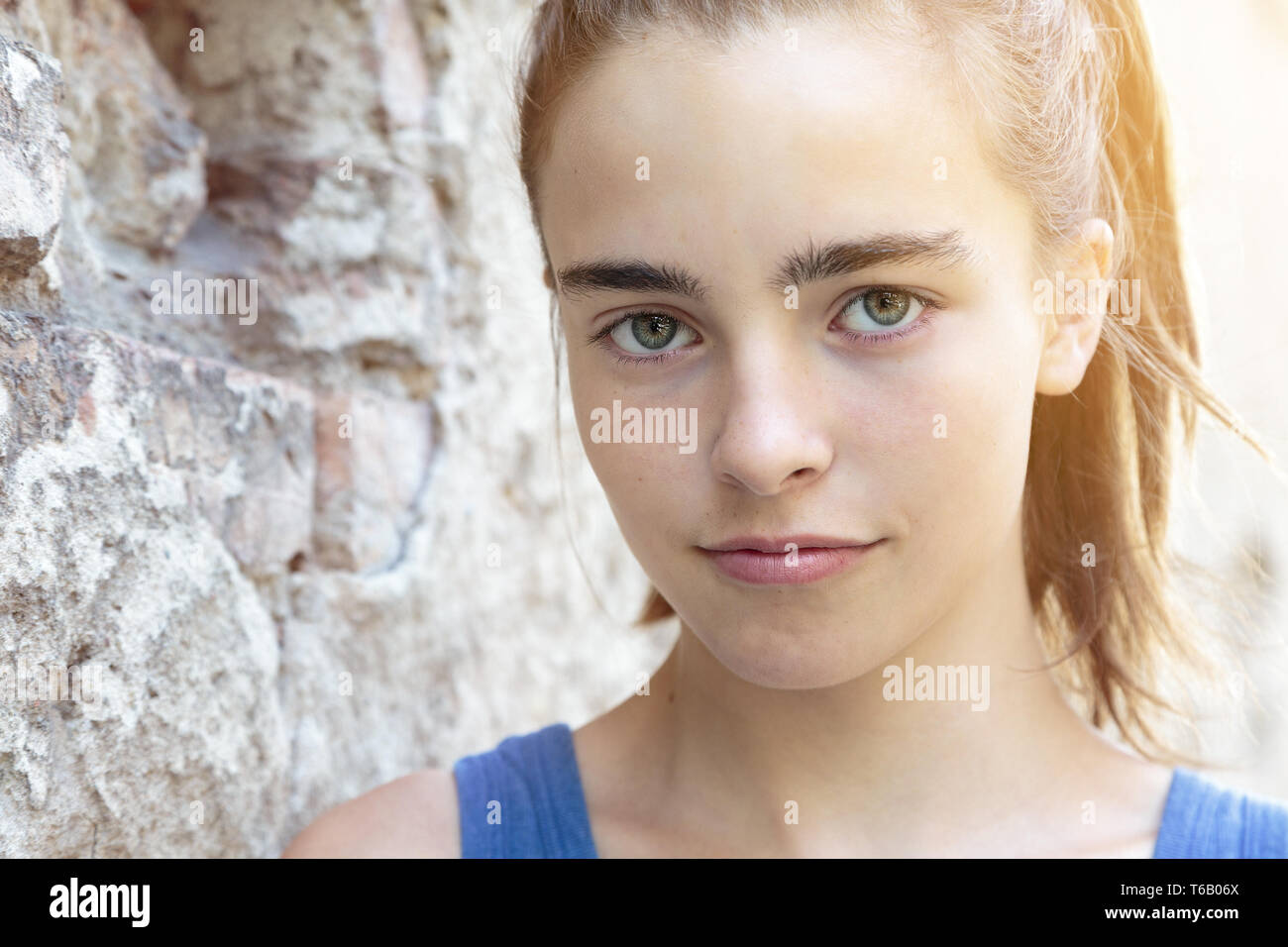 Teenage Girl Leaning Against A Wall And Smiling Hi Res Stock