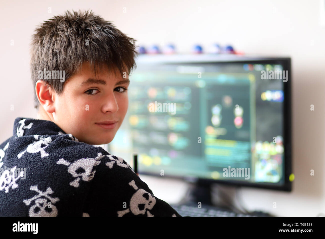 Boy using computer at home, playing game Stock Photo - Alamy