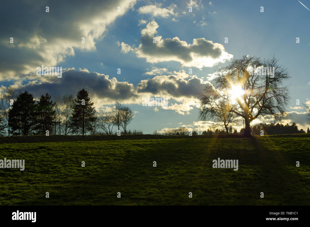 Amazing sunset over a dark green countryside landscape Stock Photo - Alamy
