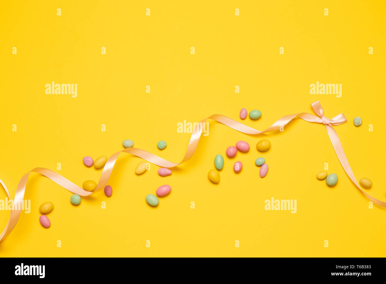Colorful candy are scattered on yellow background Stock Photo - Alamy