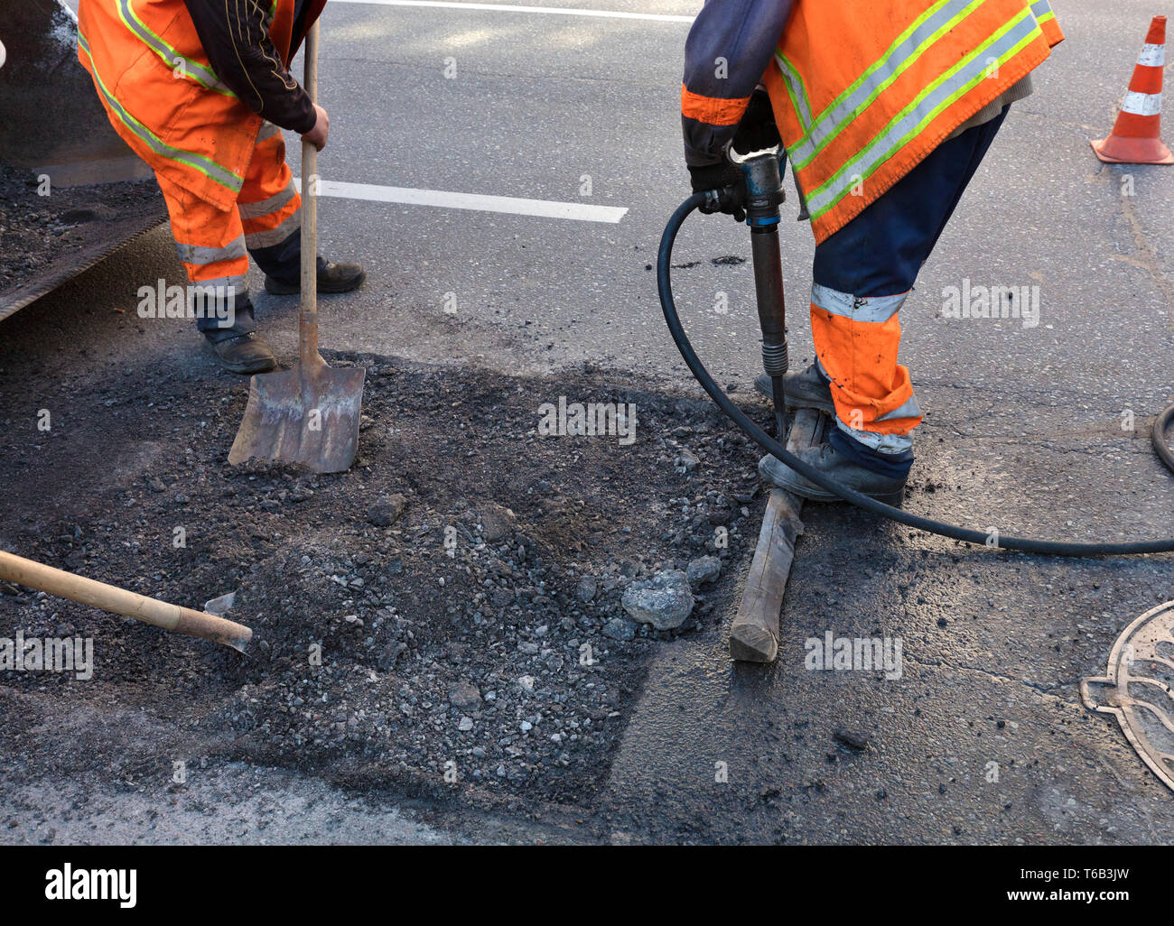a brigade of servants for road maintenance removes the old asphalt with ...