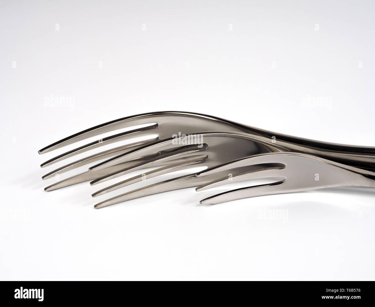 different sizes of noble forks in a side view on a white background ...