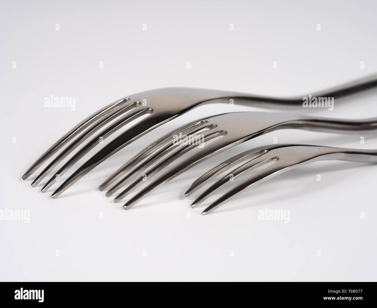 different sizes of noble forks in a bottom view on a white background ...