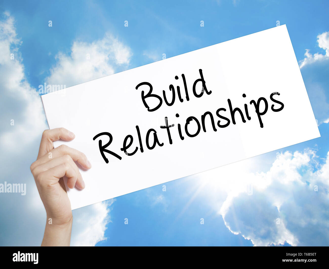 Build Relationships Sign on white paper. Man Hand Holding Paper with ...