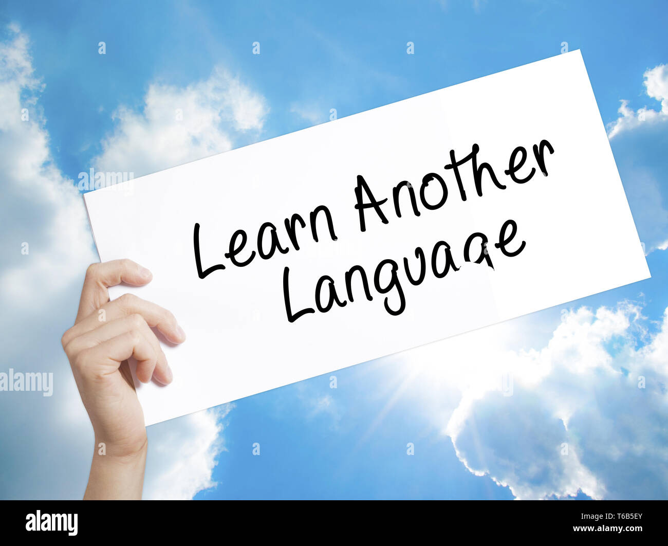 Learn Another Language Sign on white paper. Man Hand Holding Paper with ...