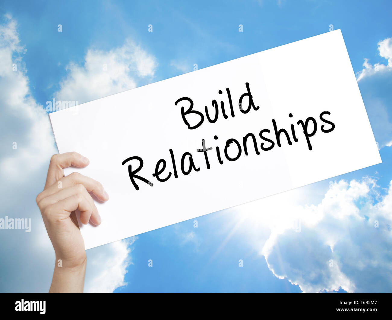 Build Relationships Sign on white paper. Man Hand Holding Paper with ...