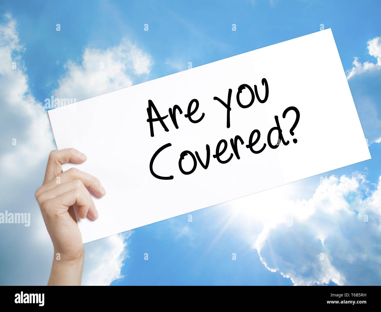 Are you Covered? Sign on white paper. Man Hand Holding Paper with text ...