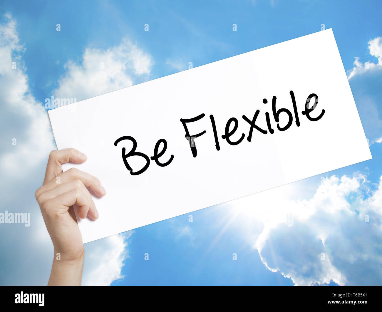 Be Flexible Sign on white paper. Man Hand Holding Paper with text ...