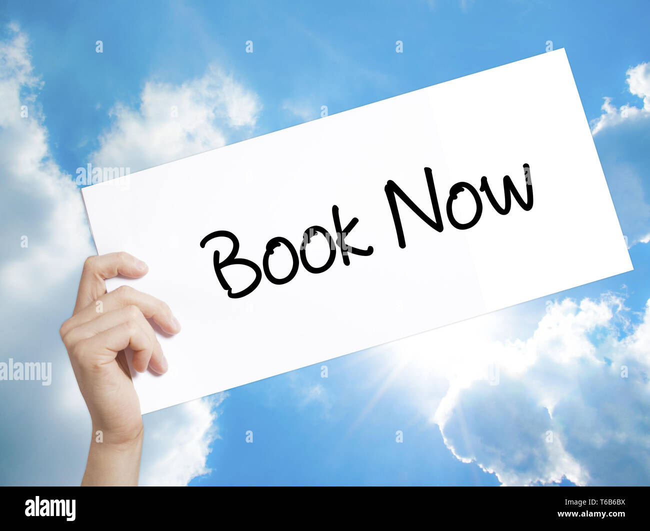 Book Now Sign on white paper. Man Hand Holding Paper with text ...