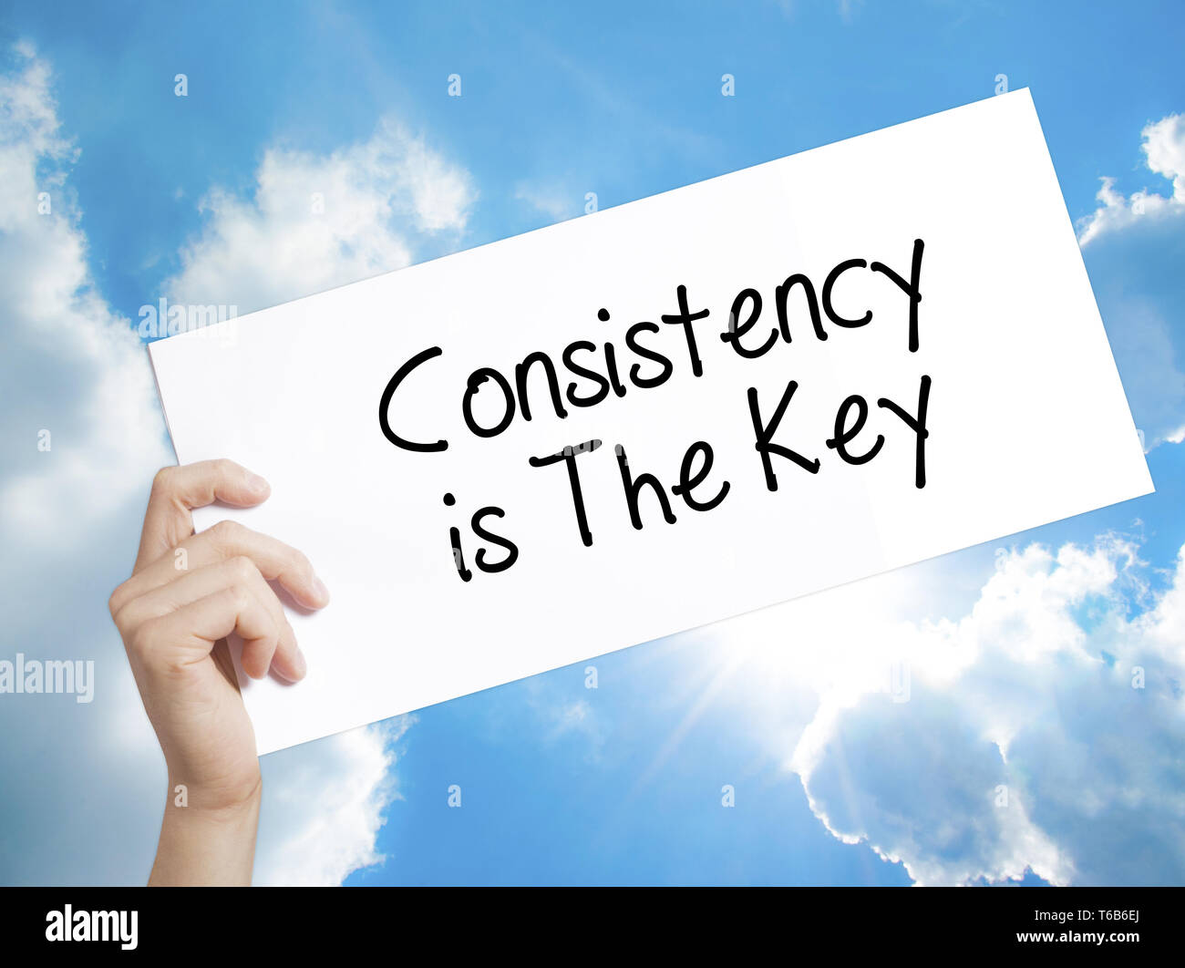 Consistency is The Key Sign on white paper. Man Hand Holding Paper with ...