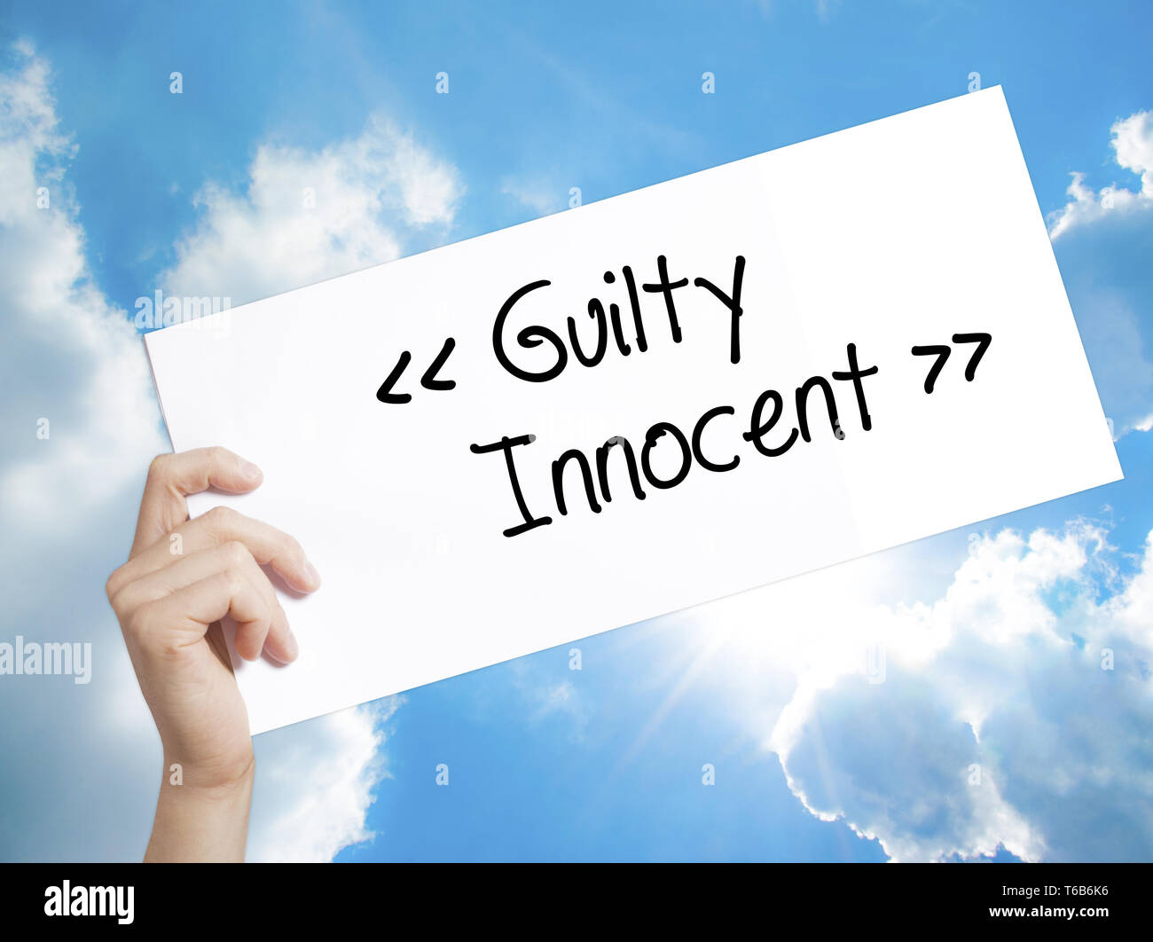 Guilty - Innocent Sign on white paper. Man Hand Holding Paper with text ...