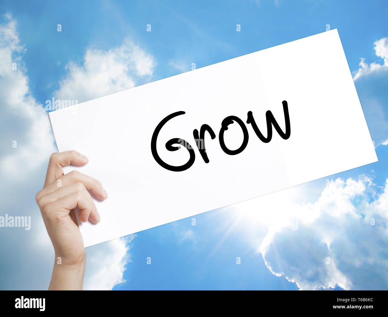 Grow Sign on white paper. Man Hand Holding Paper with text. Isolated on ...