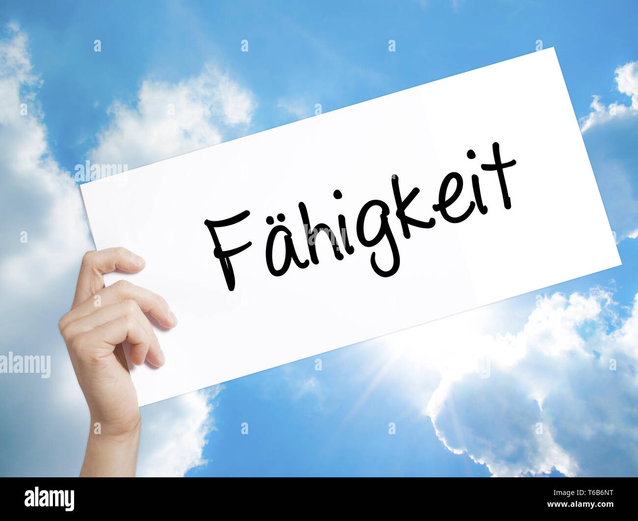 Fahigkeit (Ability in German) Sign on white paper. Man Hand Holding ...