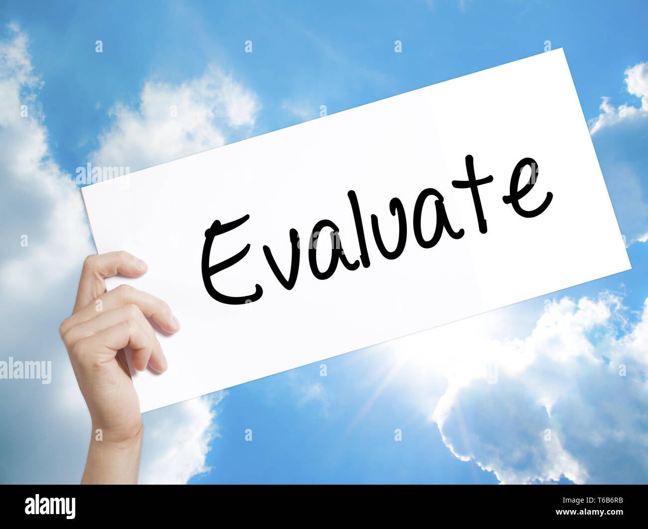 Evaluate Sign on white paper. Man Hand Holding Paper with text ...