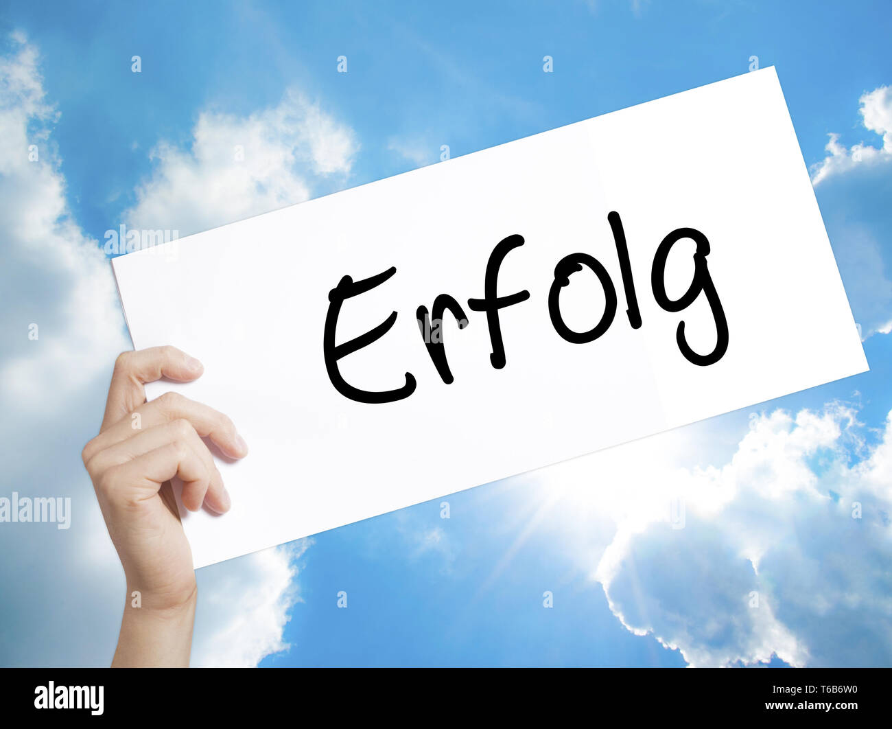 Erfolg Success (in German) Sign on white paper. Man Hand Holding Paper ...