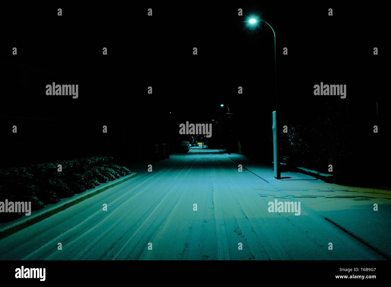 A dimly lit road with a street lamp Stock Photo - Alamy