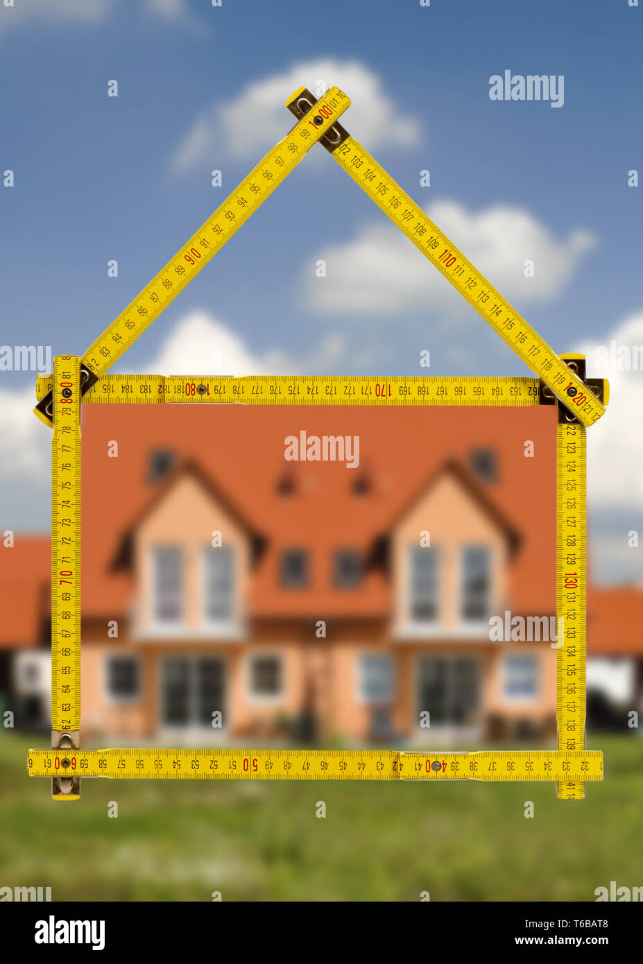 shell of house under construction with folding ruler in hand of real ...