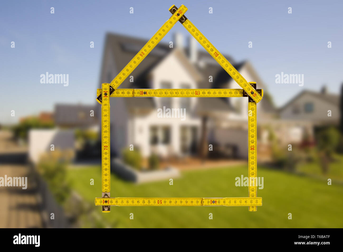 shell of house under construction with folding ruler in hand of real ...