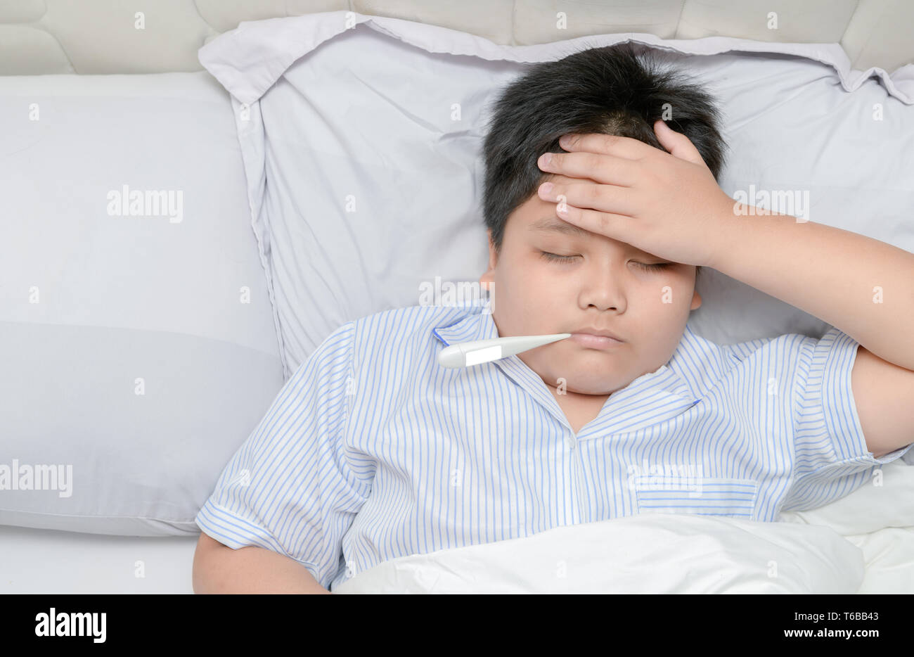 Sick child with high fever laying in bed and Measure fever with ...