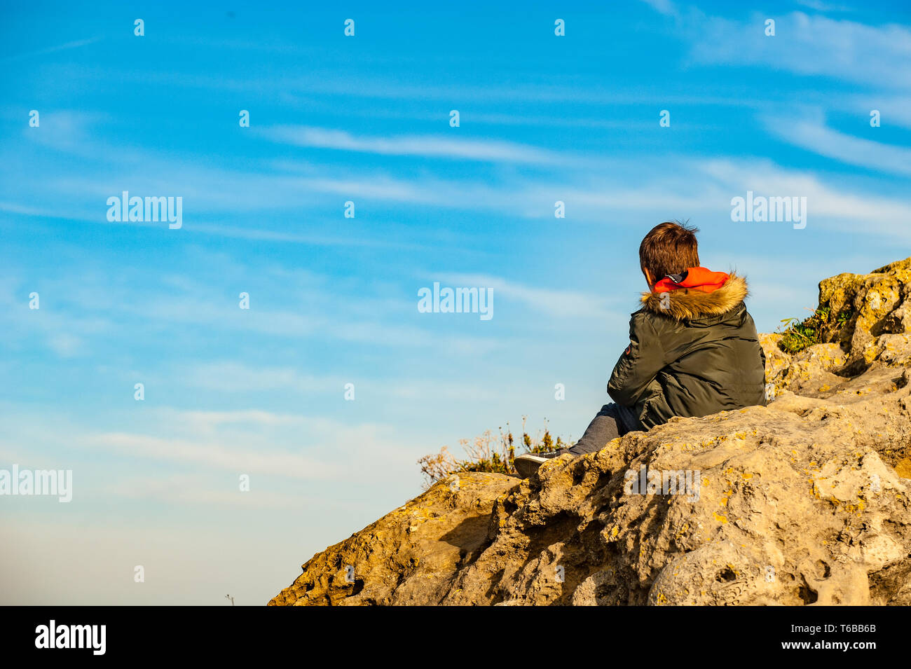 Boy sitting on rocks beach hi-res stock photography and images - Alamy