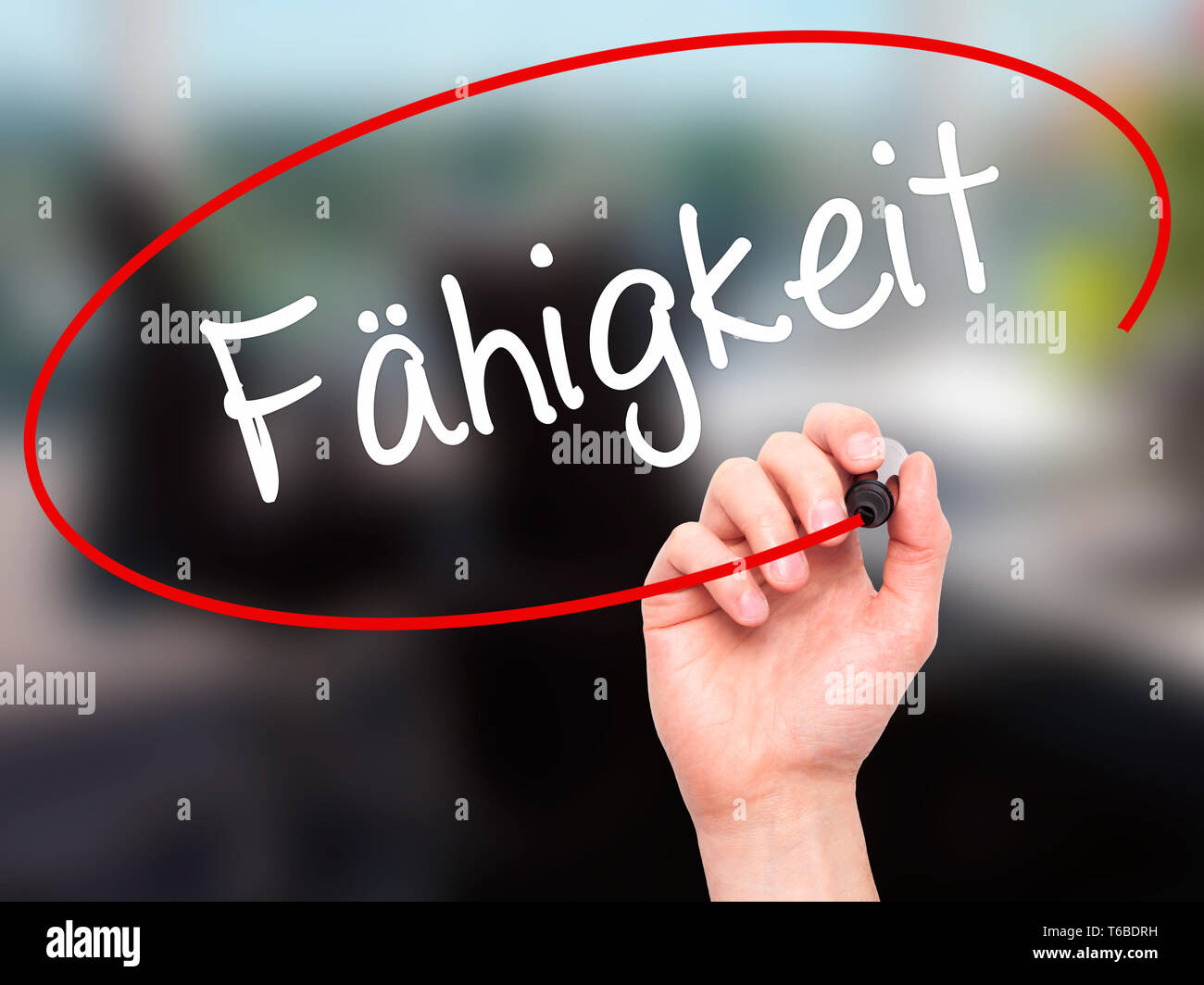 Man Hand writing Fahigkeit (Ability in German) with black marker on ...
