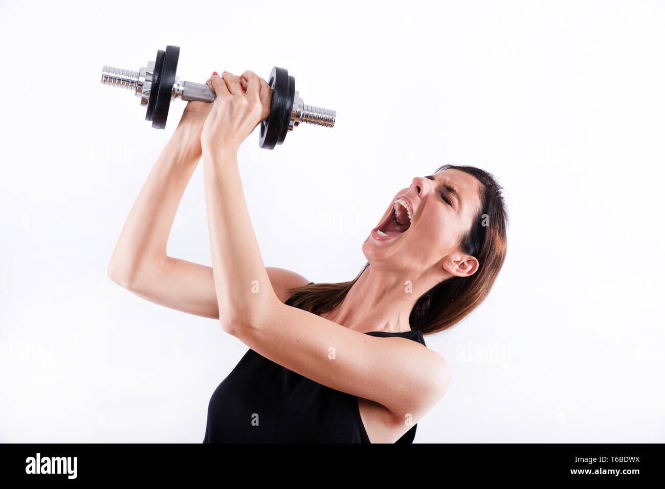 A beautiful young woman lifting weight and screaming Stock Photo - Alamy