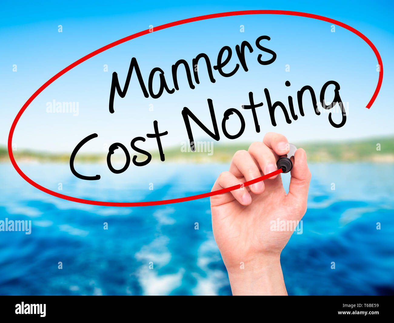 Man Hand writing Manners Cost Nothing with black marker on visual ...