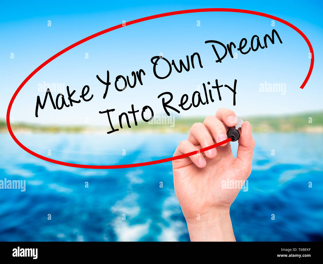 Man Hand writing Make Your Own Dream Into Reality with black marker on ...