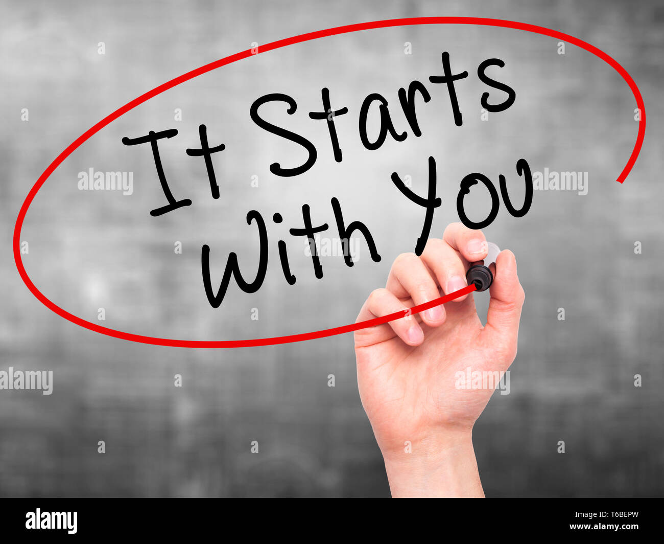 Man Hand writing It Starts With You with black marker on visual screen ...