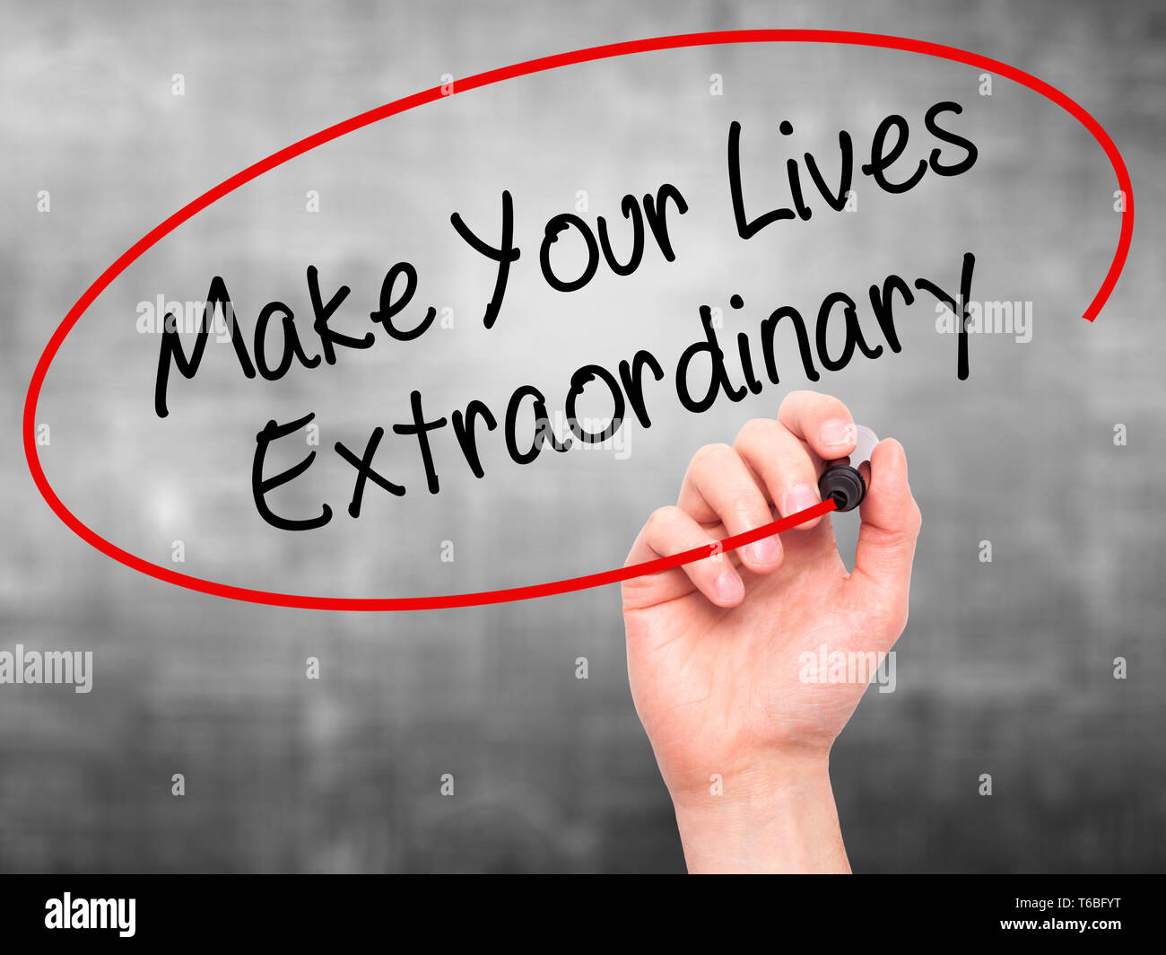 Man Hand writing Make Your Lives Extraordinary with black marker on ...