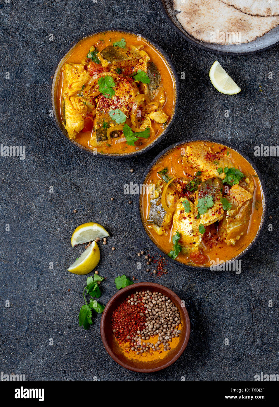 INDIAN FOOD. Traditional KERALA FISH CURRY with naan bread, gray plate ...