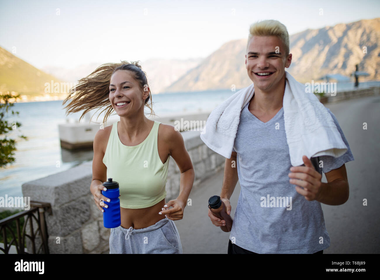 Happy fit people couple jogging and running outdoors Stock Photo - Alamy