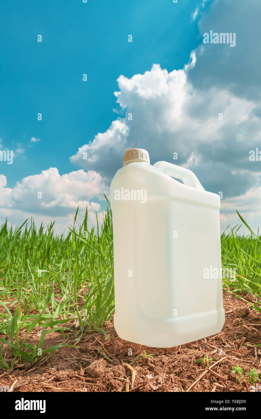 Blank pesticide jug container mock up in wheatgrass field. Using ...