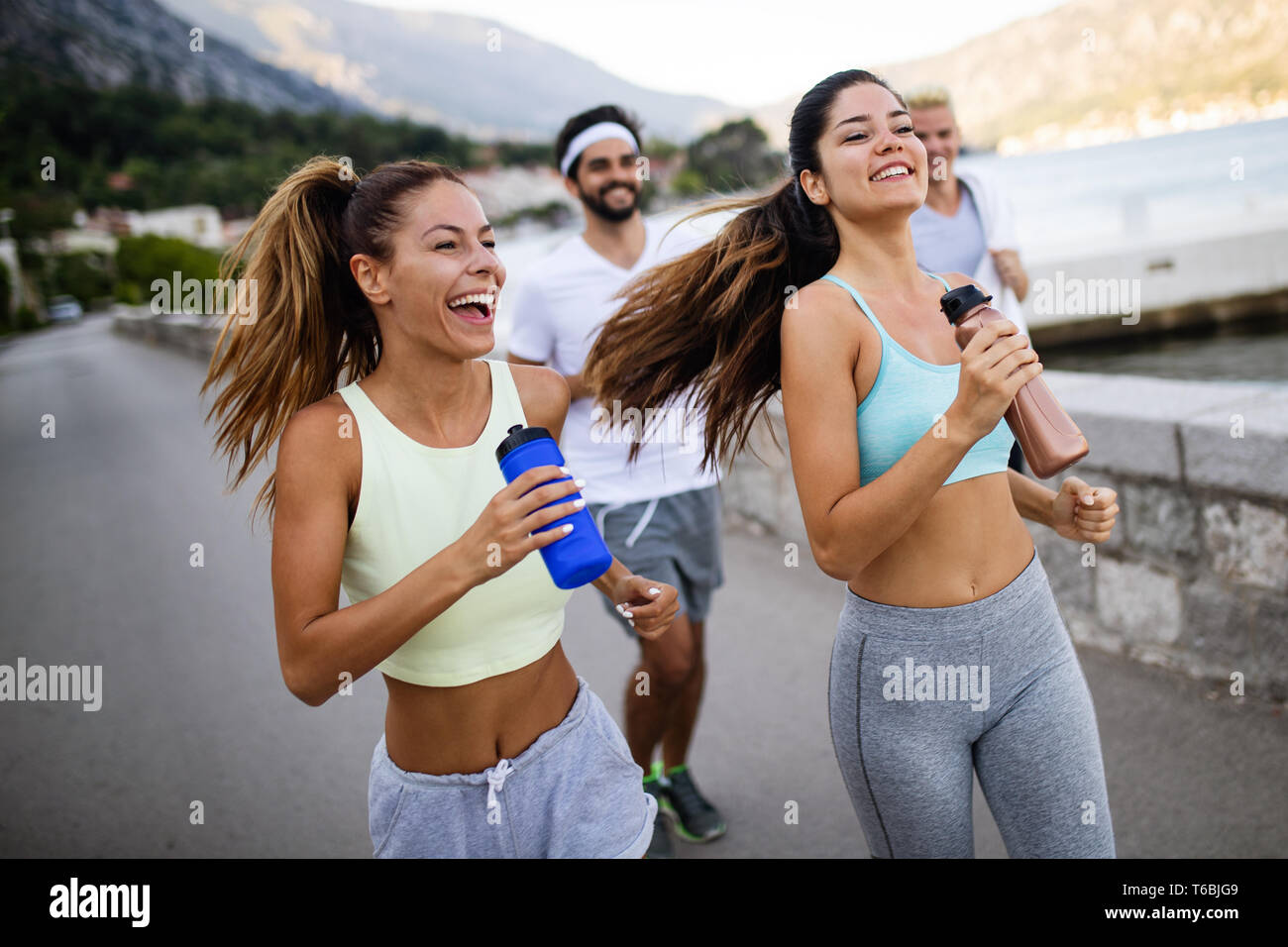 Outdoor portrait of group of friends running and jogging in nature ...