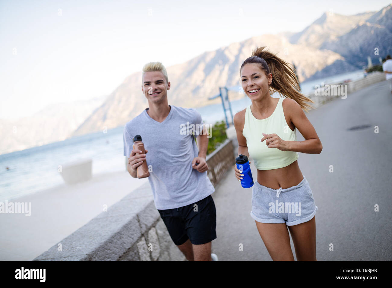 Happy fit people couple jogging and running outdoors Stock Photo - Alamy