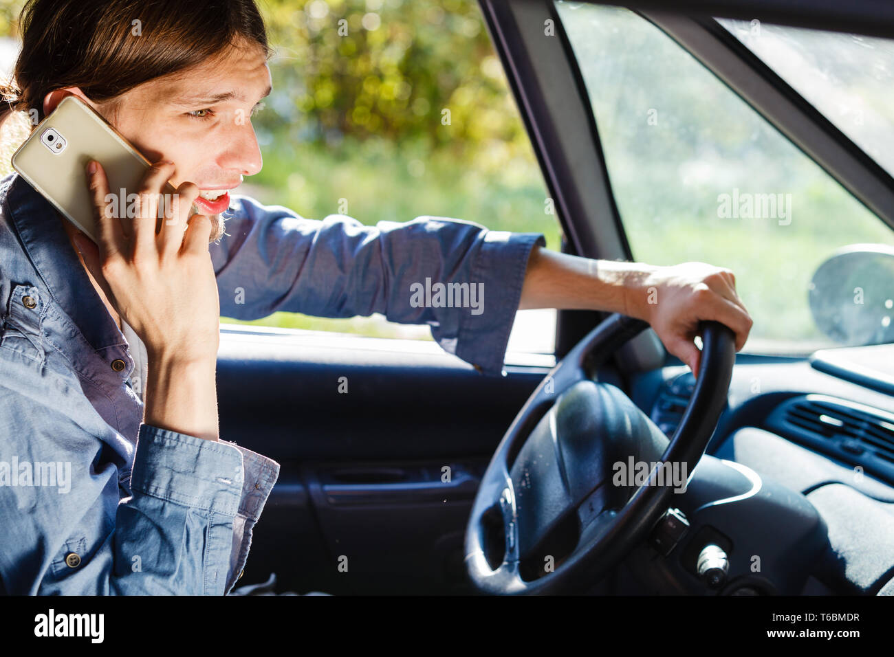 Talking while drive, danger fresh driver concept. Young man driving car ...