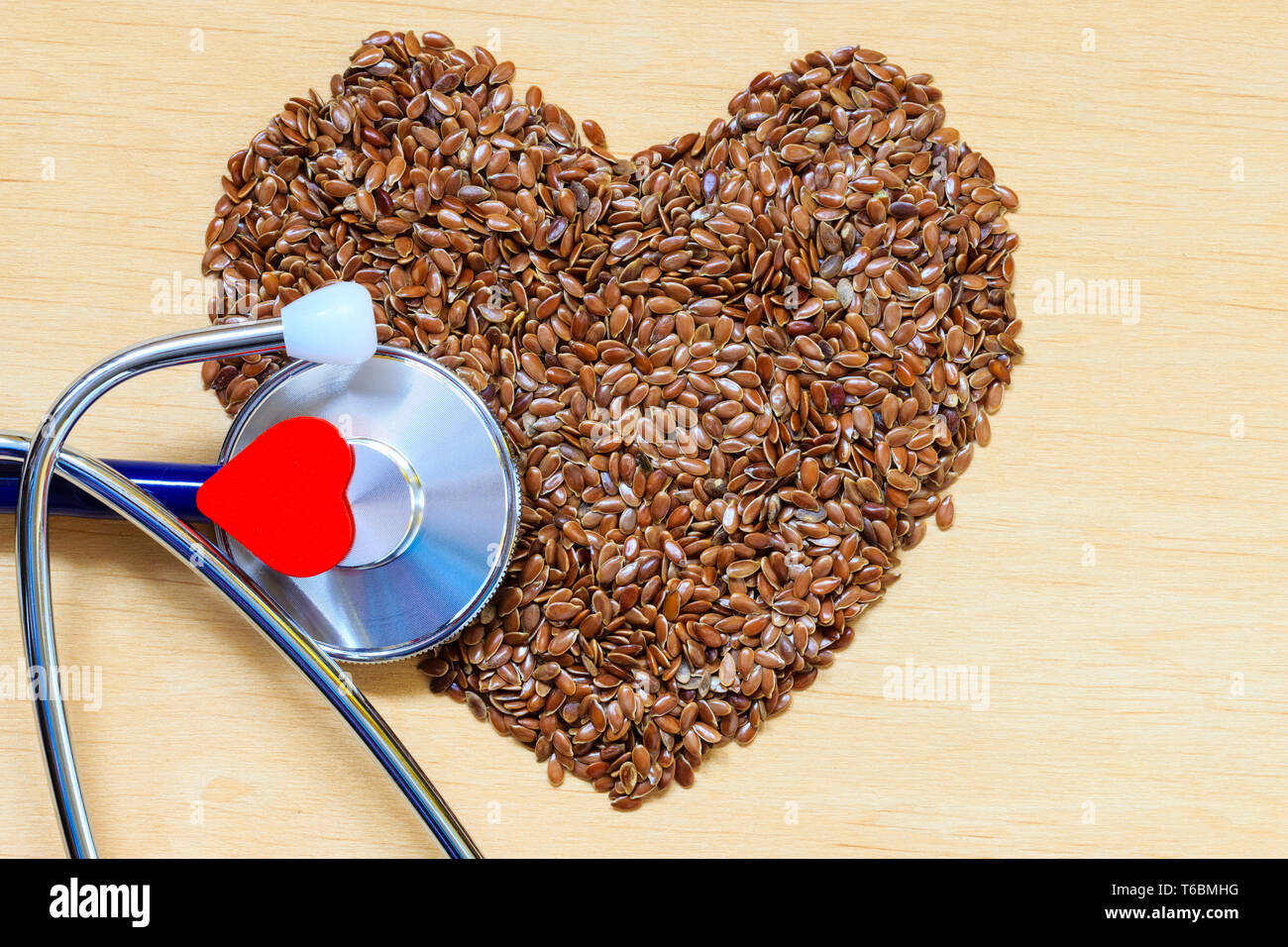 Diet healthcare and checkup concept. Raw flax seeds linseed heart shaped and stethoscope ...