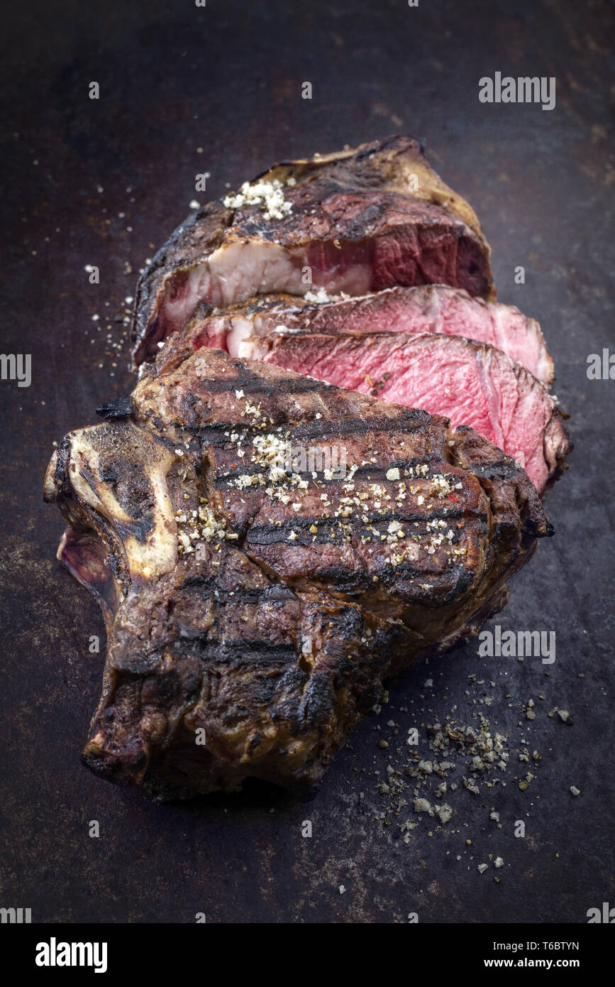 Barbecue dry aged Rib of Beef as close-up on a rusty metal sheet Stock ...
