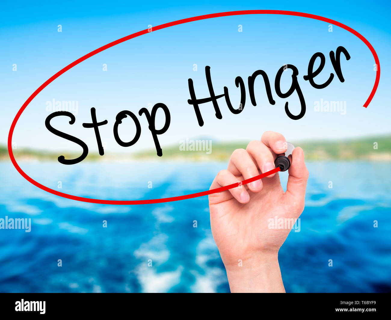 Man Hand writing Stop Hunger with black marker on visual screen Stock ...