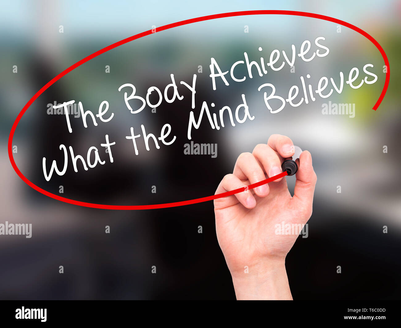Man Hand writing The Body Achieves What the Mind Believes with black ...