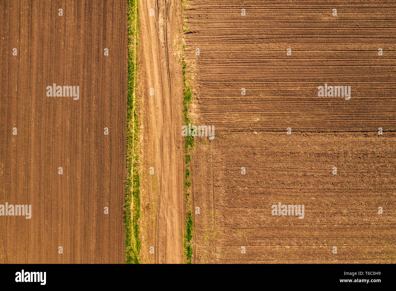 Aerial view of dirt road through countryside and agricultural field ...