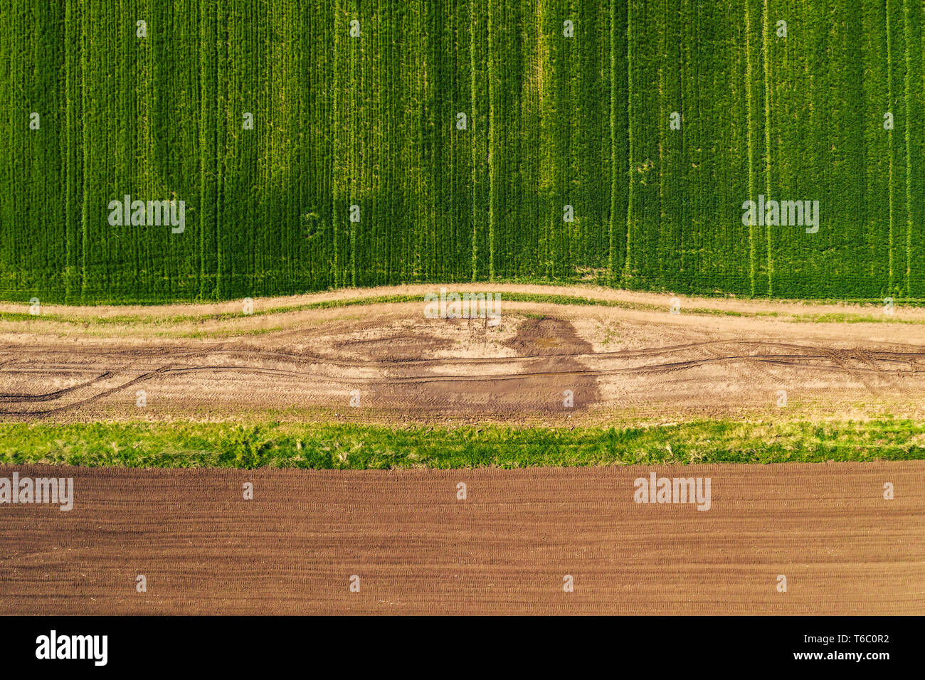 Aerial view of dirt road through countryside and agricultural field ...