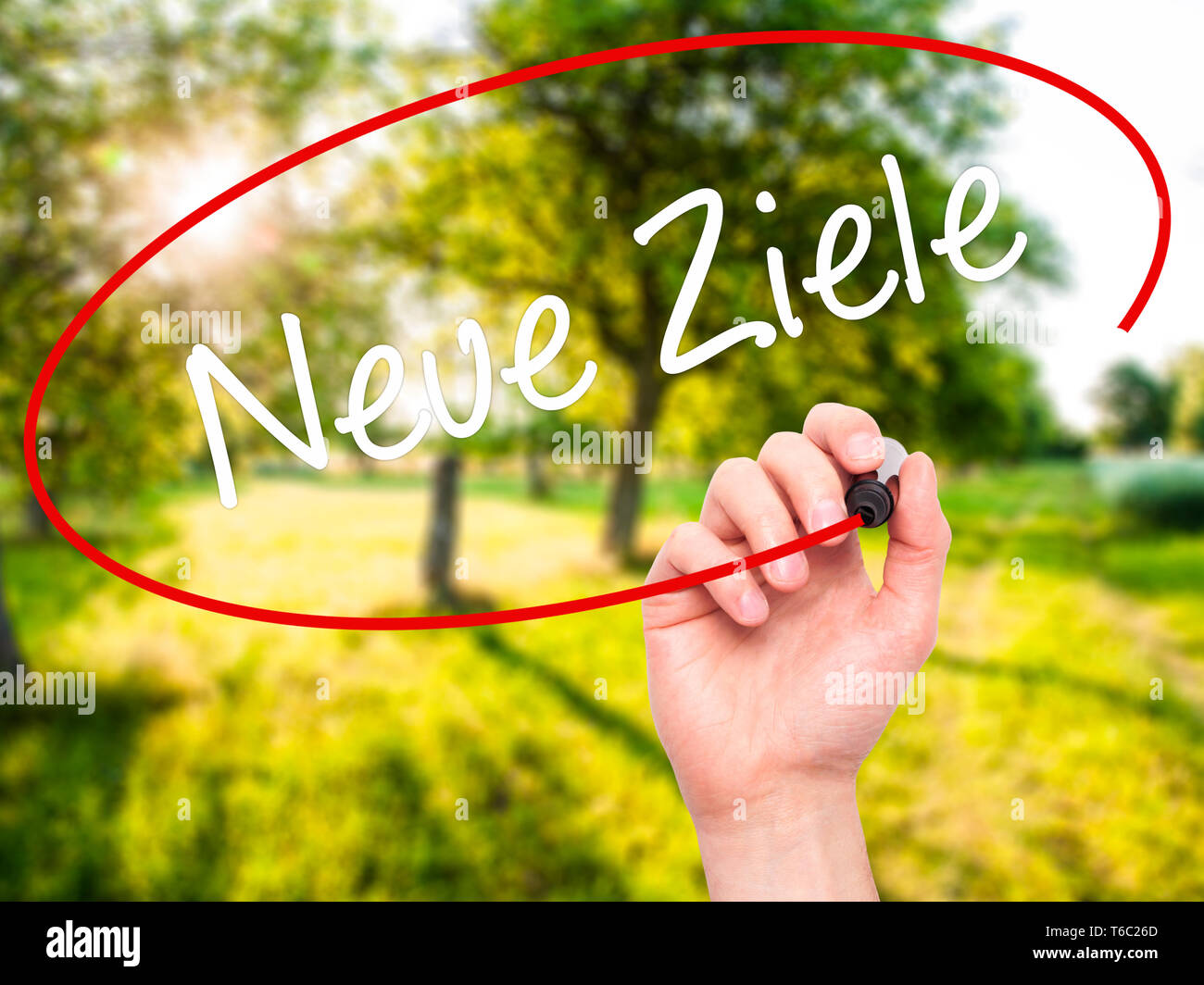 Man Hand writing Neue Ziele (New Goals in German) with black marker on ...